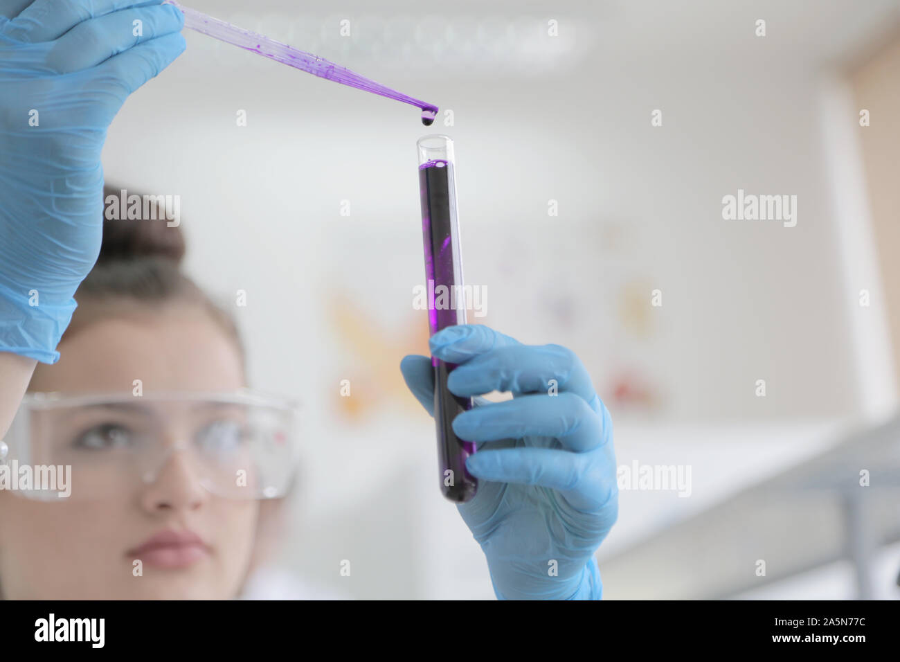 Young female Laboratory scientist working at lab with test tubes and ...