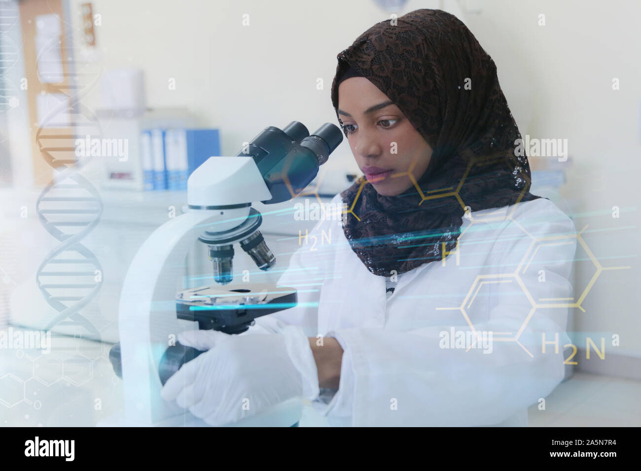 Young african muslim female scientist looking through a microscope in a ...