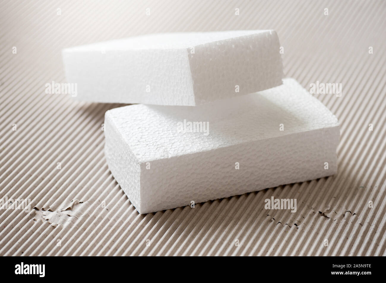 Closeup white polystyrene foam on corrugated paper. Polystyrene foam is ...