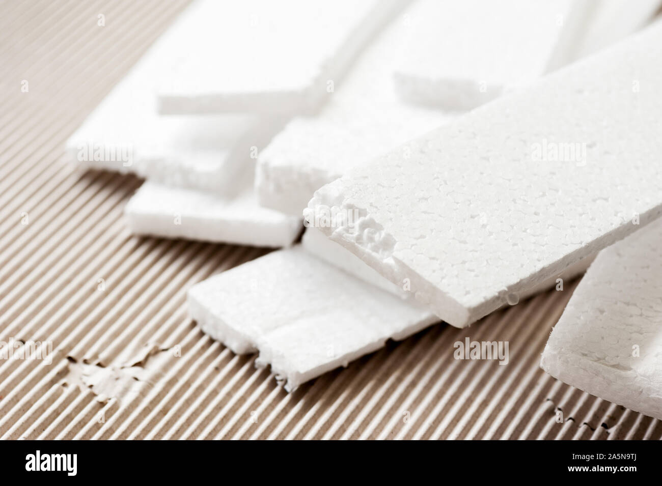 Closeup white polystyrene foam on corrugated paper. Polystyrene foam is ...