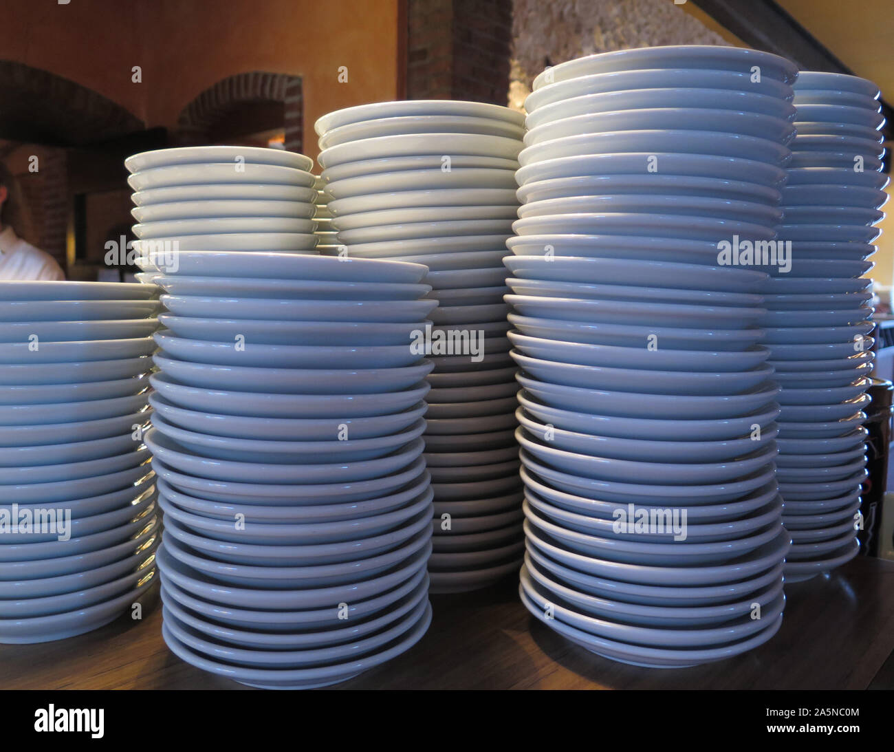 Plates stacked high on restaurant counter in Holland Stock Photo - Alamy