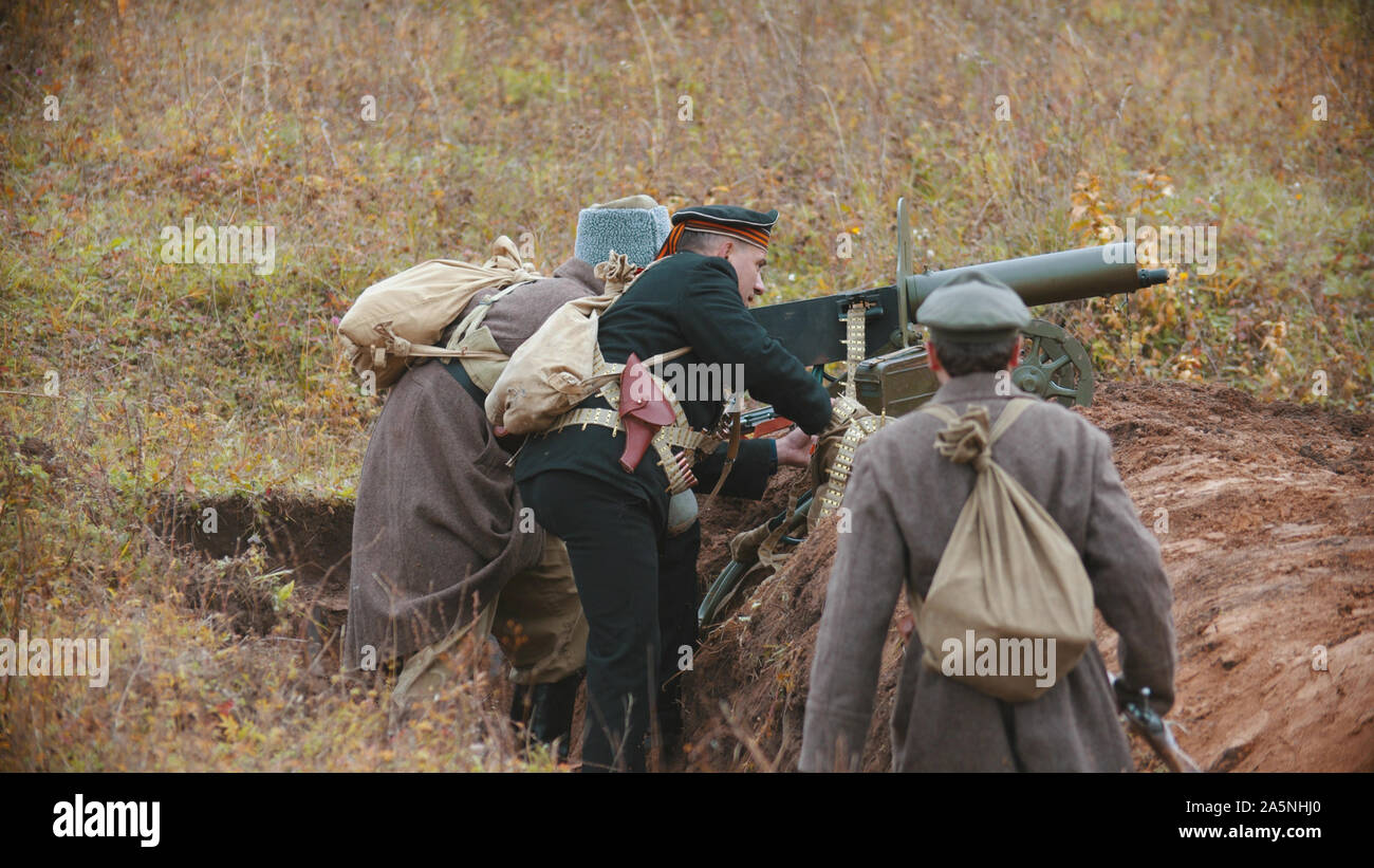 Military men in the trench are getting ready to shoot from a gun ...