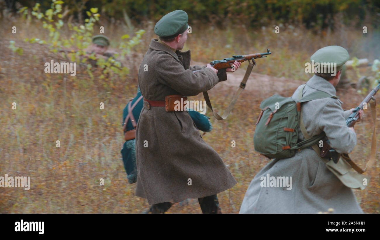 Three soldiers on the field are shooting in their enemies. Mid shot ...