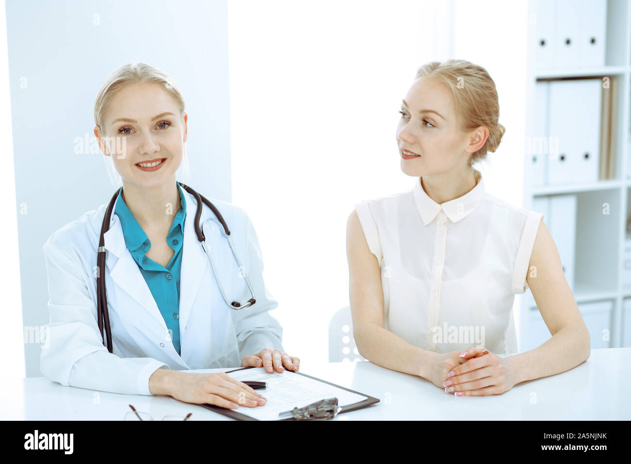 Doctor and patient sitting at the desk. The physician or therapist ...
