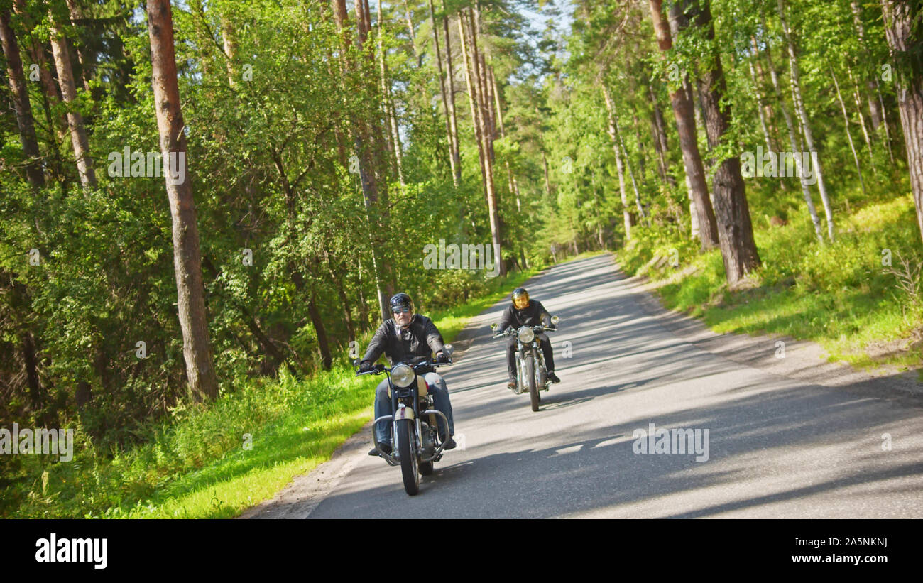 Two bikers are riding by each other along the road in the beatiful ...