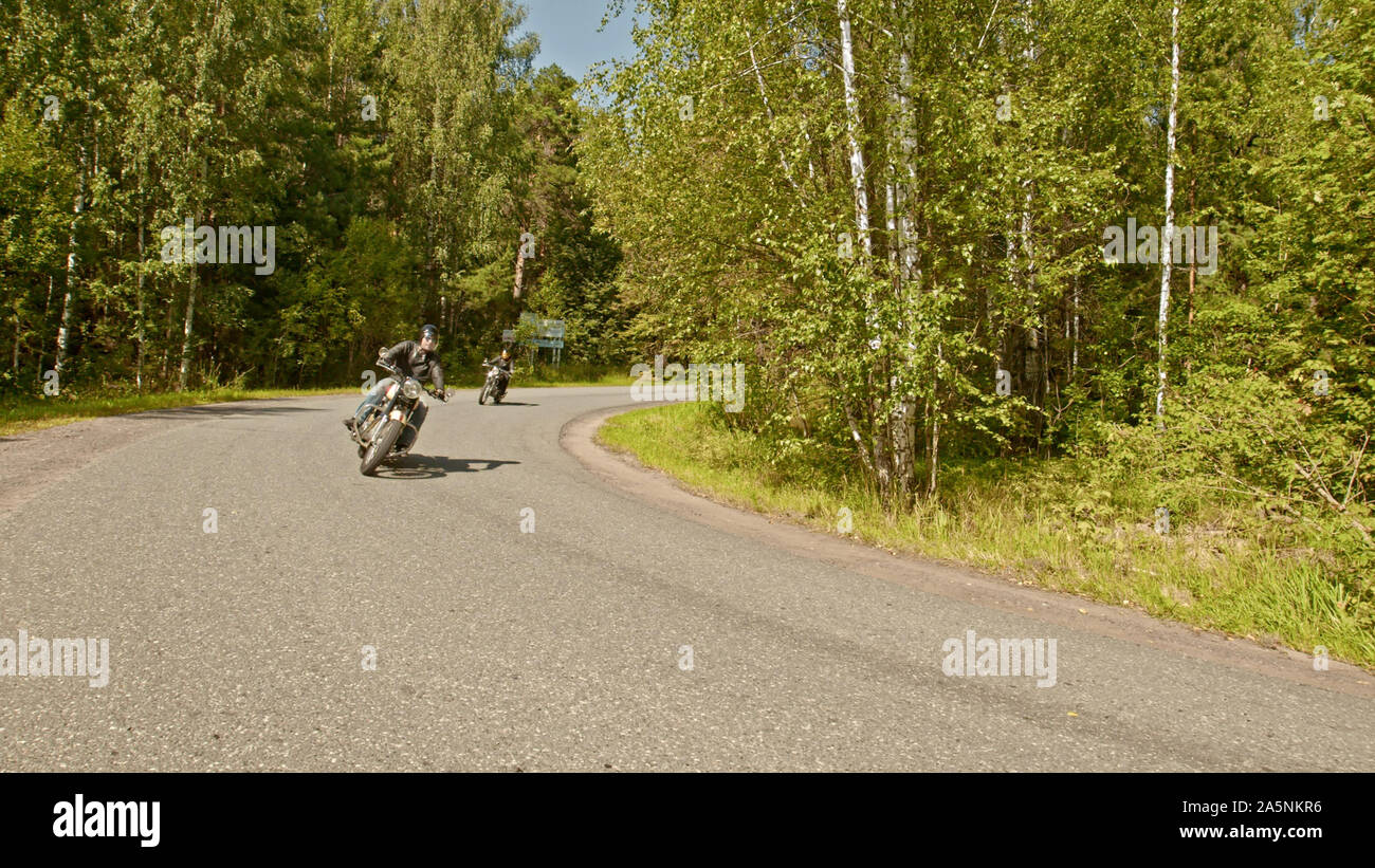 Two bikers is turning on the road in the forest - outdoor Stock Photo ...