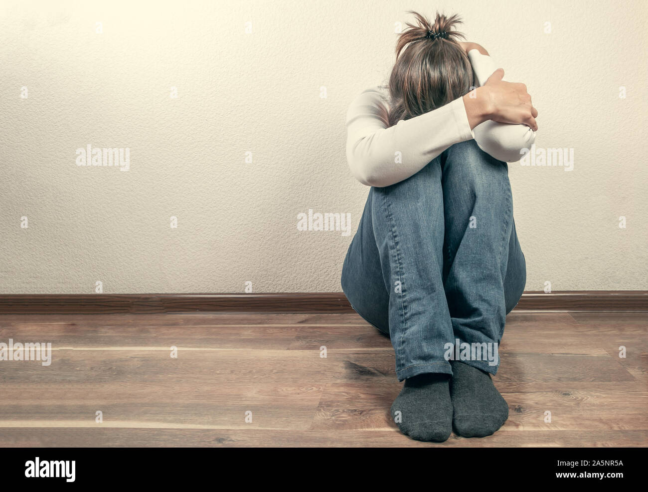 Depressed woman sitting on the floor Stock Photo - Alamy