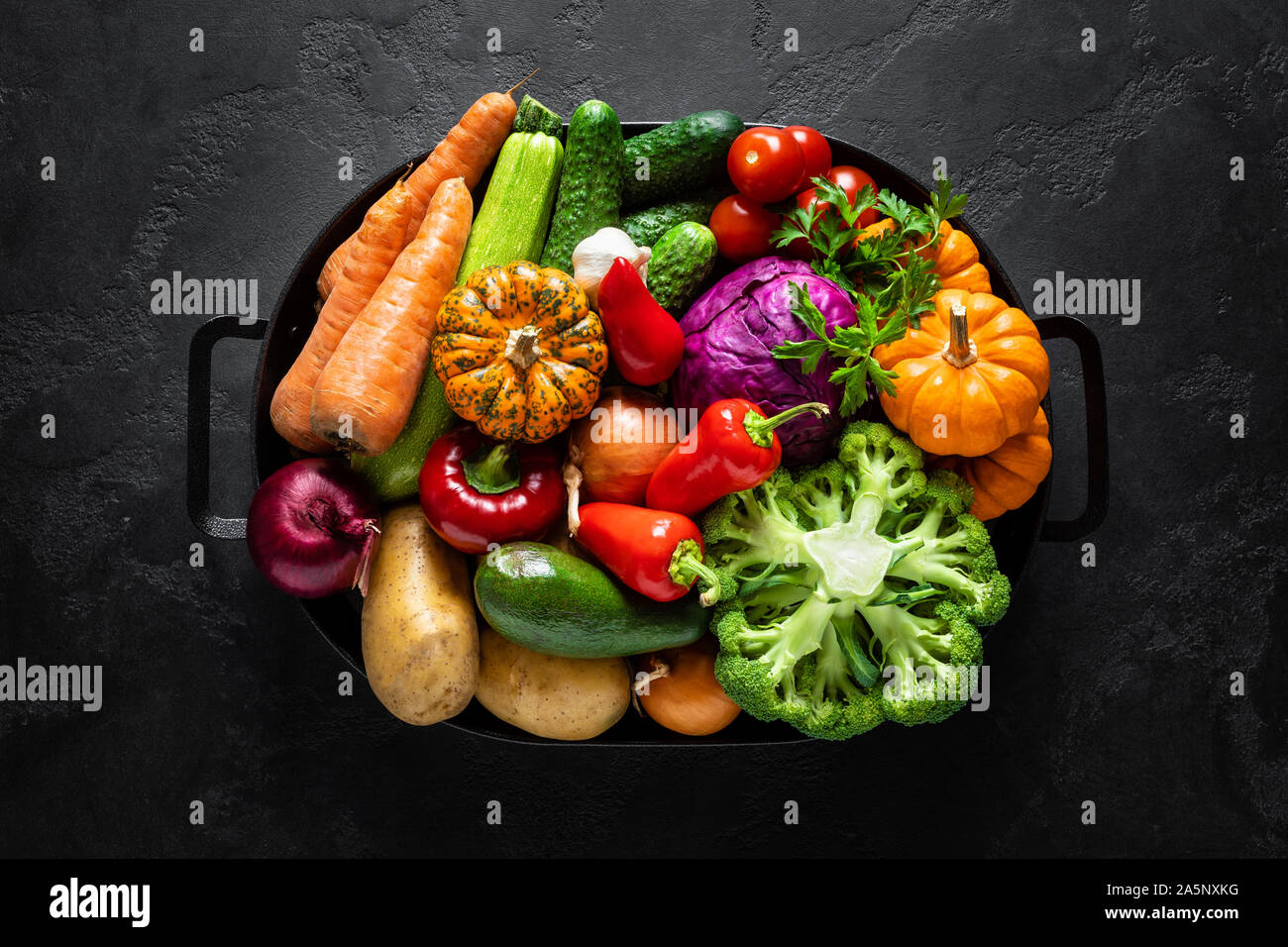 Culinary background with fresh raw vegetables on a black kitchen table ...
