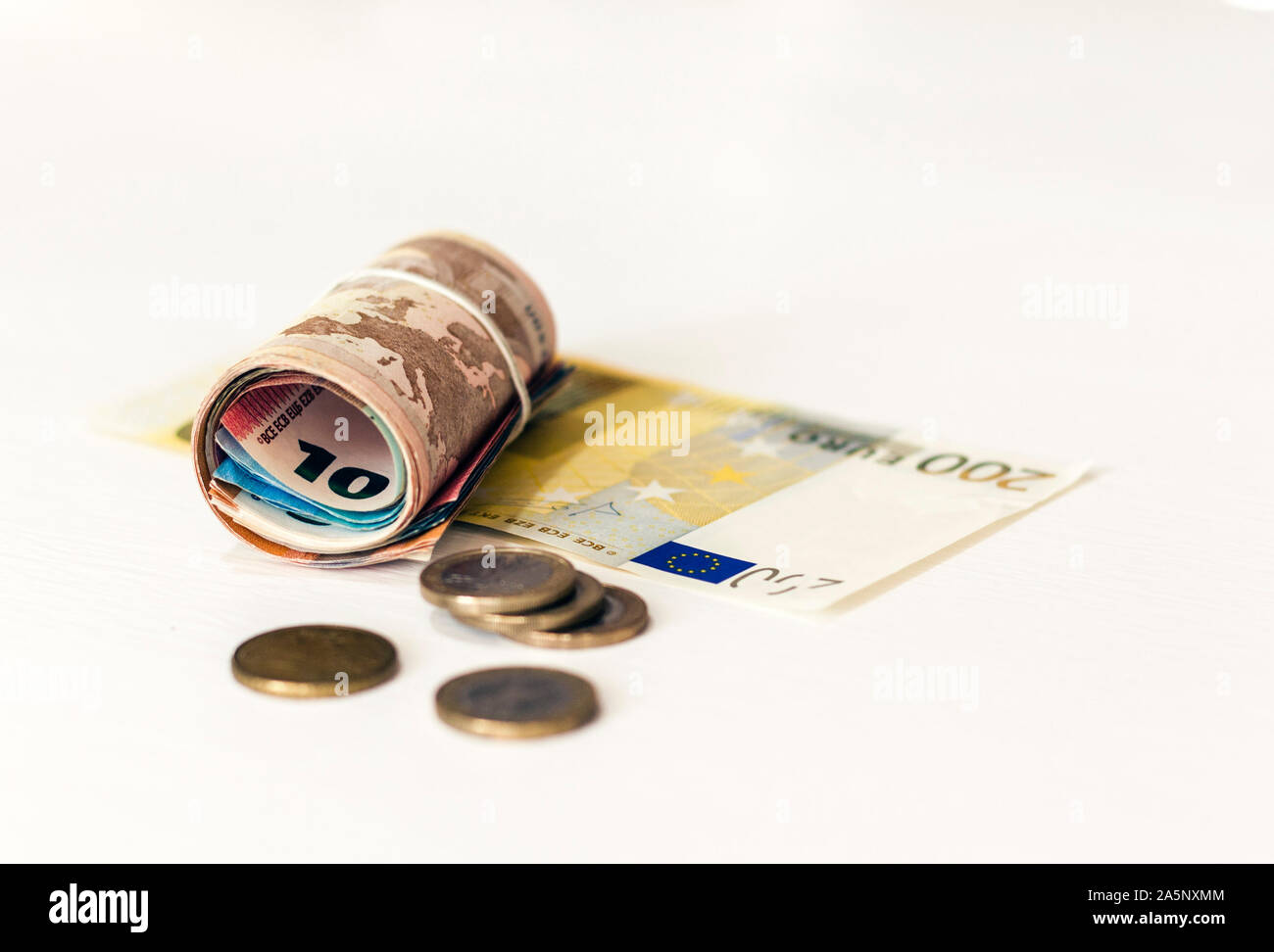 Rolled up money euro banknotes and coins on white background Stock ...