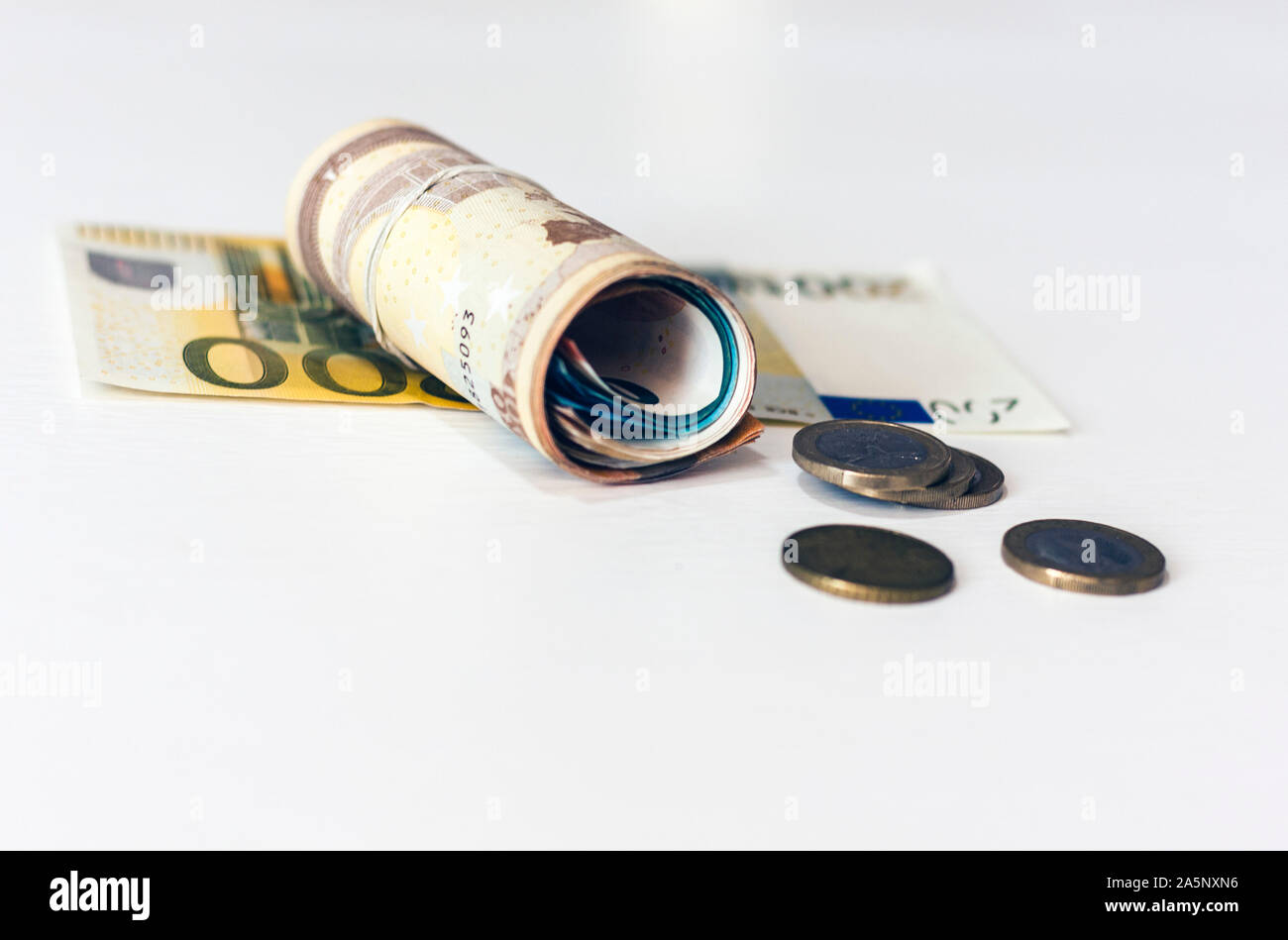 Rolled up money euro banknotes and coins on white background Stock ...