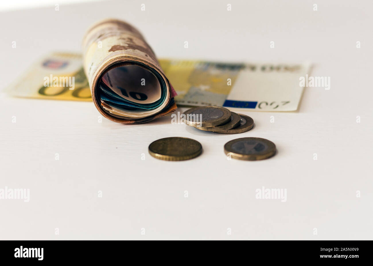Rolled up money euro banknotes and coins on white background Stock ...