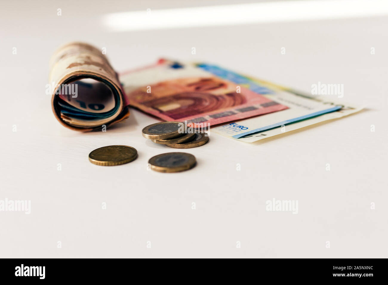 Rolled up money euro banknotes and coins on white background Stock ...