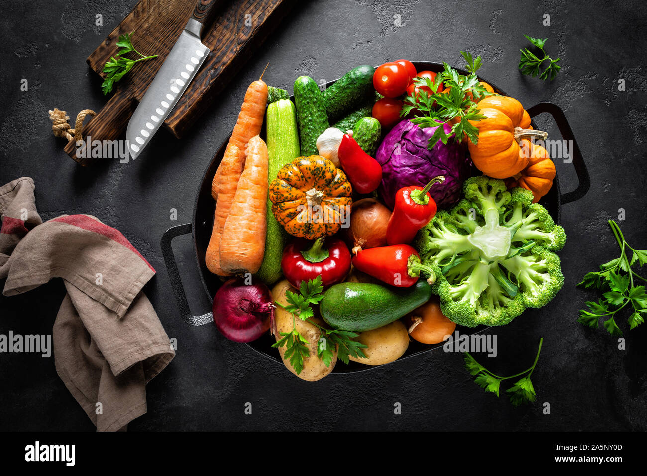 Culinary background with fresh raw vegetables on a black kitchen table ...
