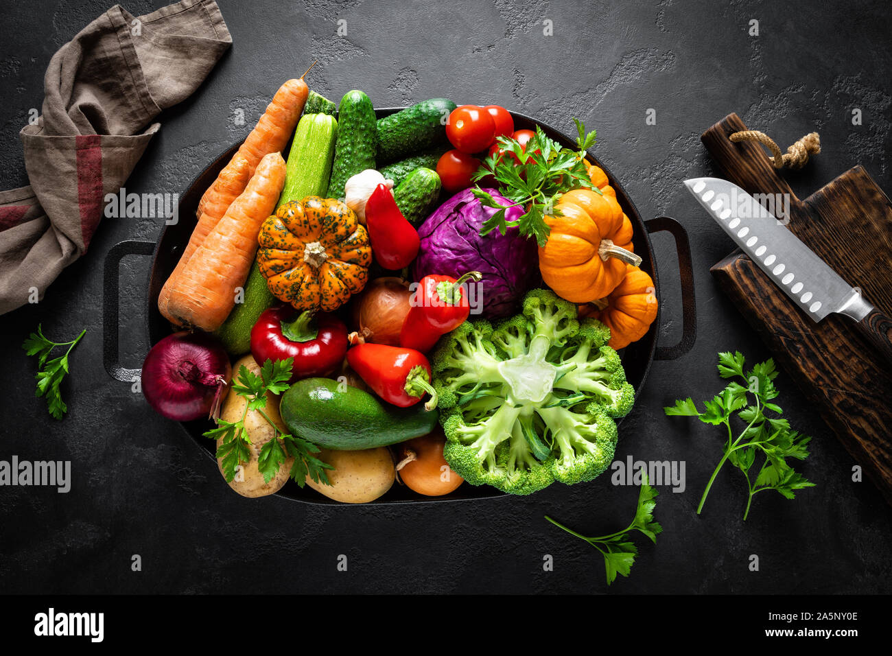 Culinary background with fresh raw vegetables on a black kitchen table ...