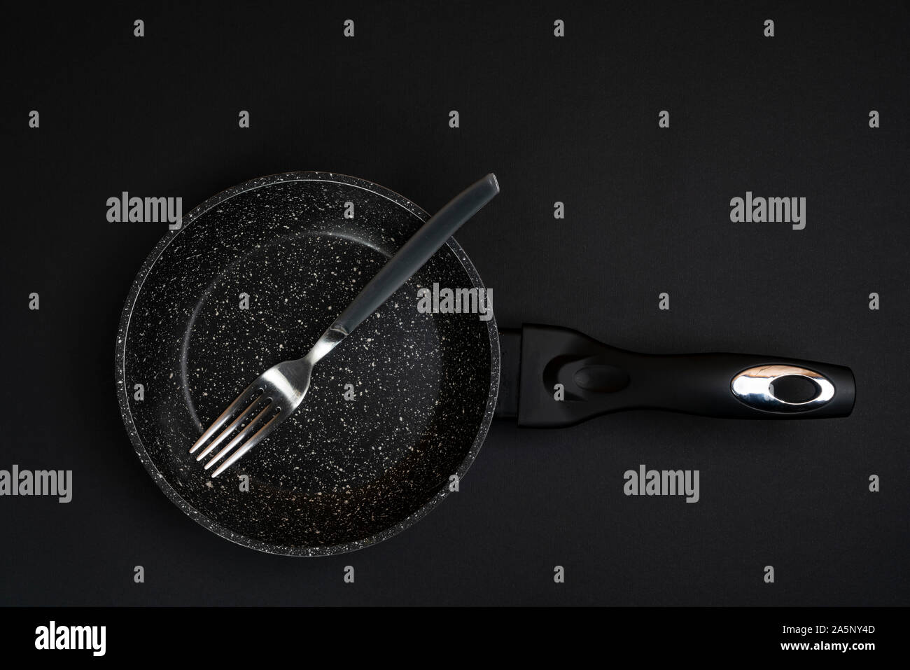 a fork in a pan on a black surface Stock Photo - Alamy