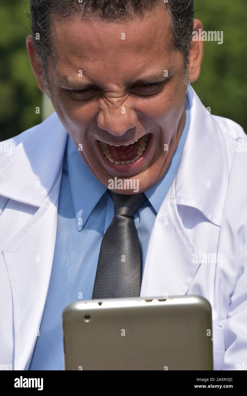 Angry Male Hispanic Doctor Using Tablet Stock Photo - Alamy