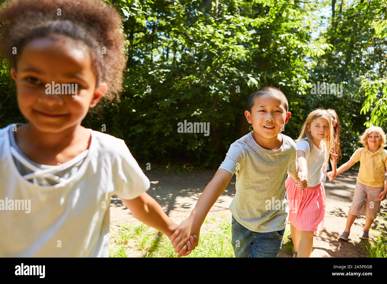 Group of children in the international kindergarten go hand in hand ...