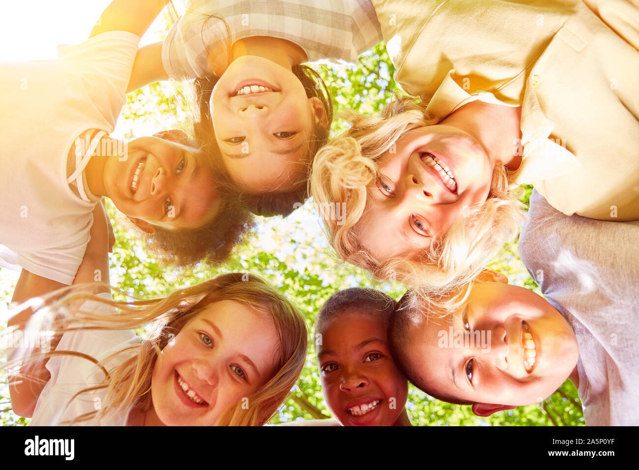Integration by happy multicultural kids in circle in summer in nature ...