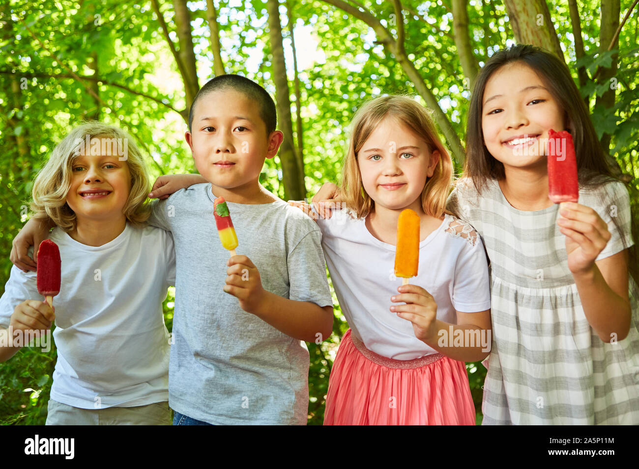Multicultural group of kids as friends having ice cream in summer Stock ...