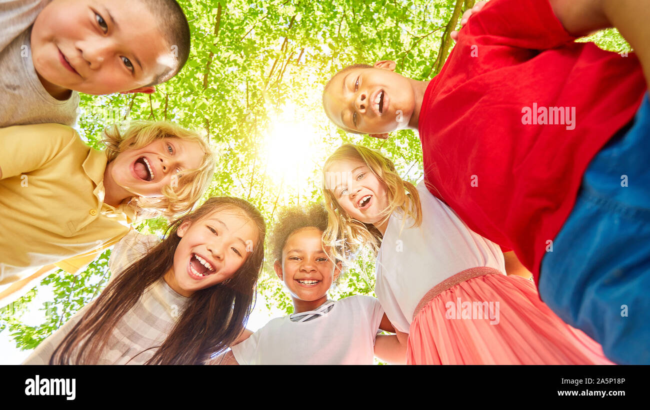 International multicultural group of kids laughs together in nature ...