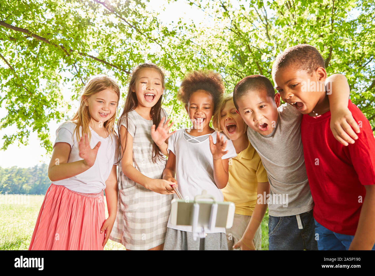 Group of multicultural kids as friends wave for a self portrait Stock ...