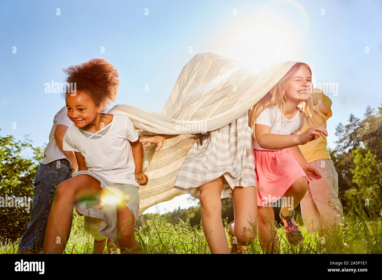 Children in summer camp play with a cloth in the summer in nature Stock ...