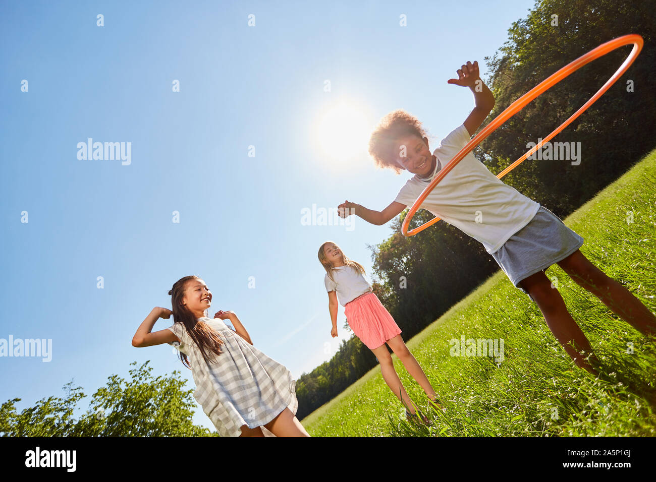 African girl with hoops in the park is being cheered by girlfriends ...