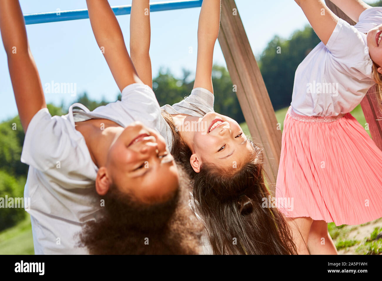 Happy children doing gymnastics on a playground during the summer ...
