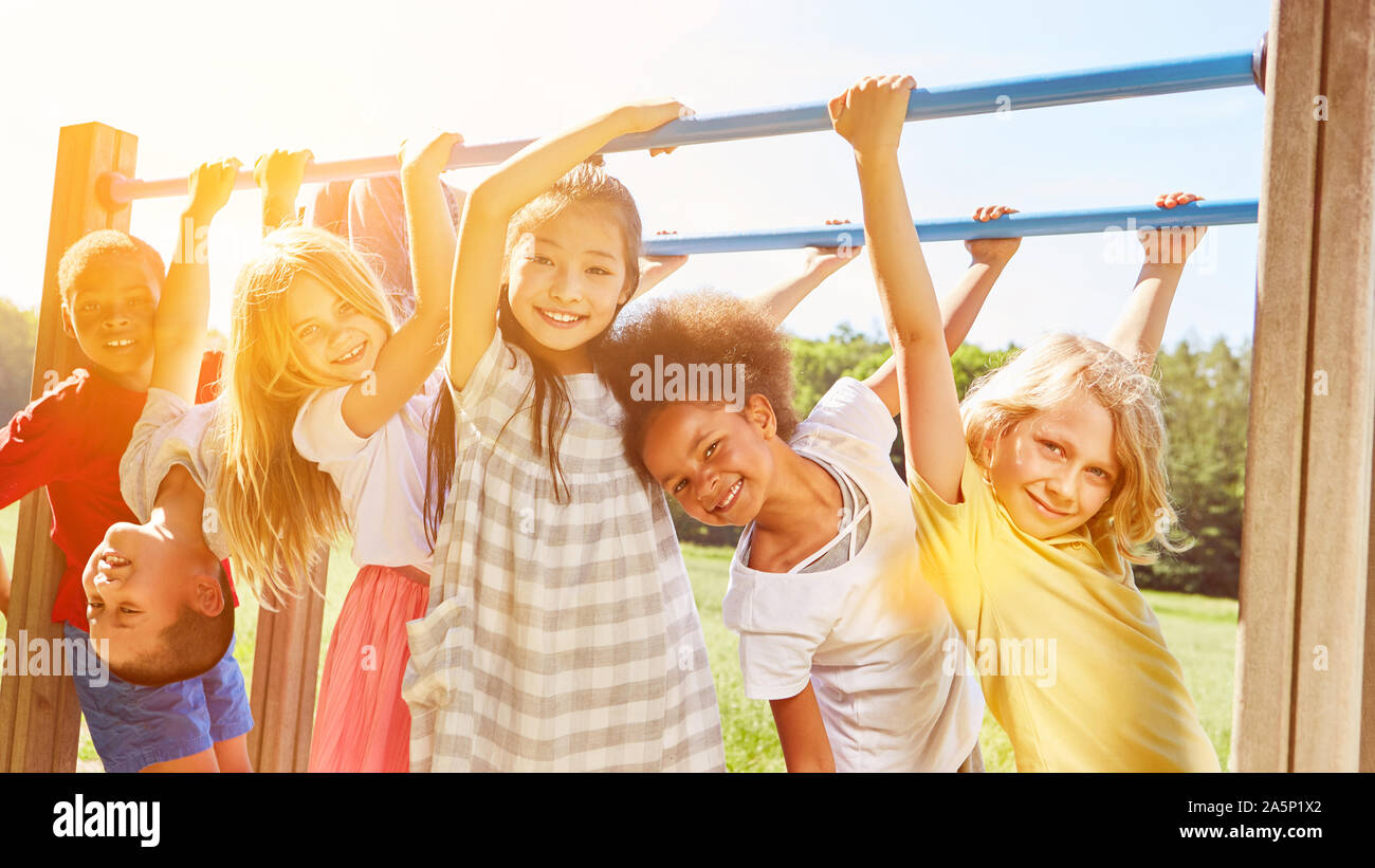 Group of children plays together at climbing frame on a playground in ...
