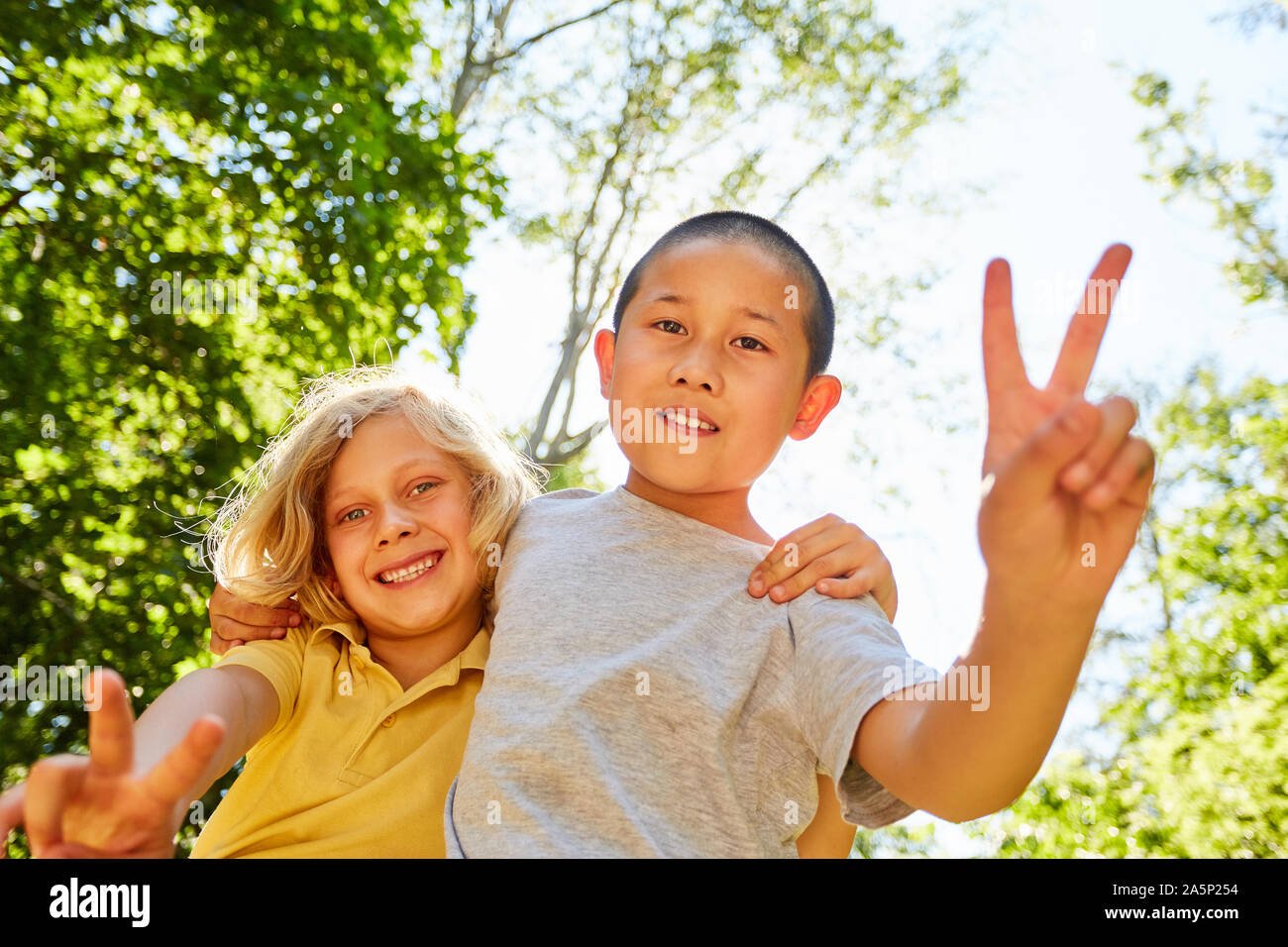 Two multicultural boys as friends in winner pose in summer camp Stock ...