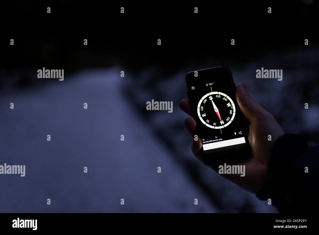 Hand holding cell phone showing compass Stock Photo - Alamy