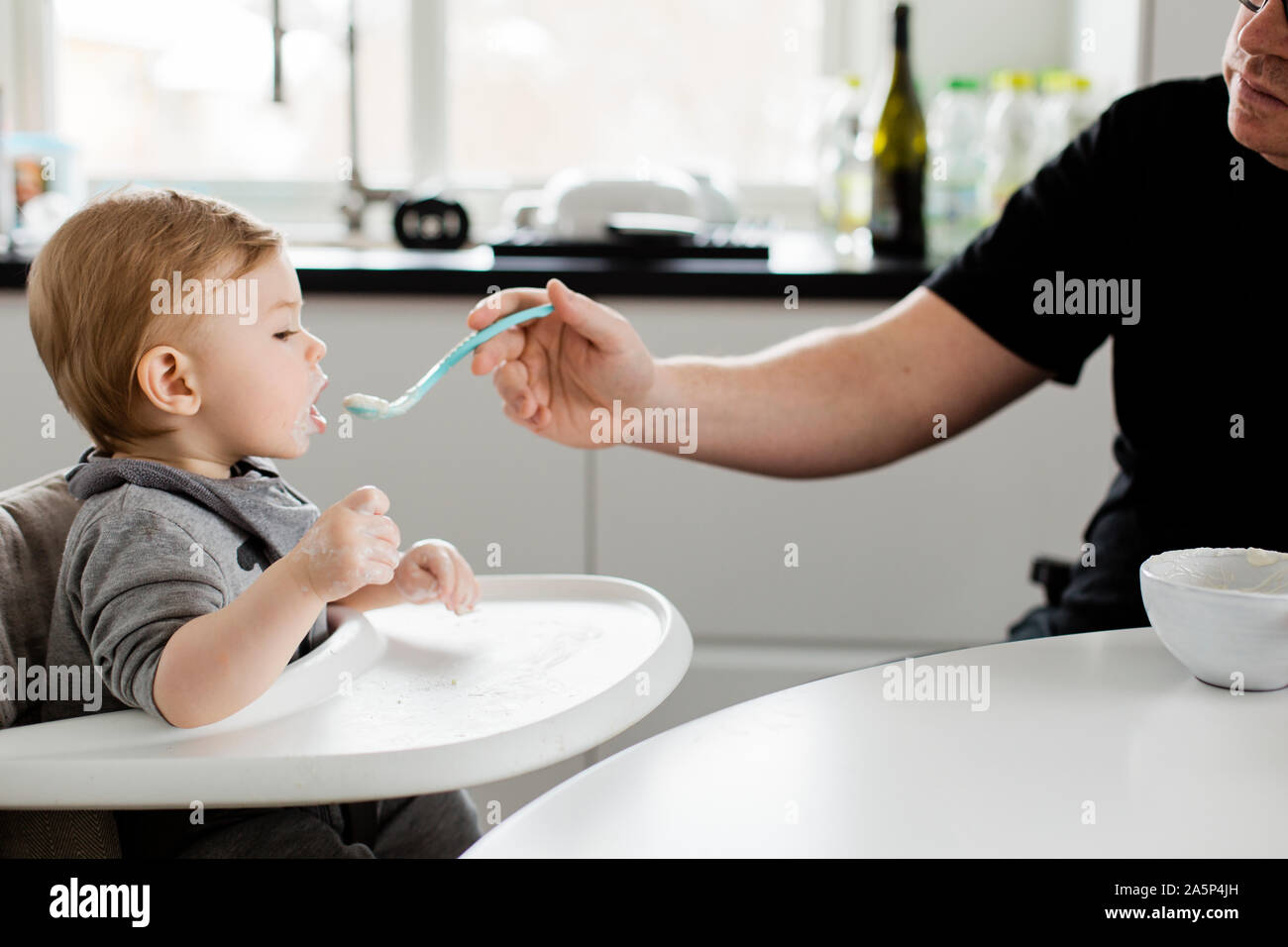 Man feeding baby high chair hi-res stock photography and images - Alamy