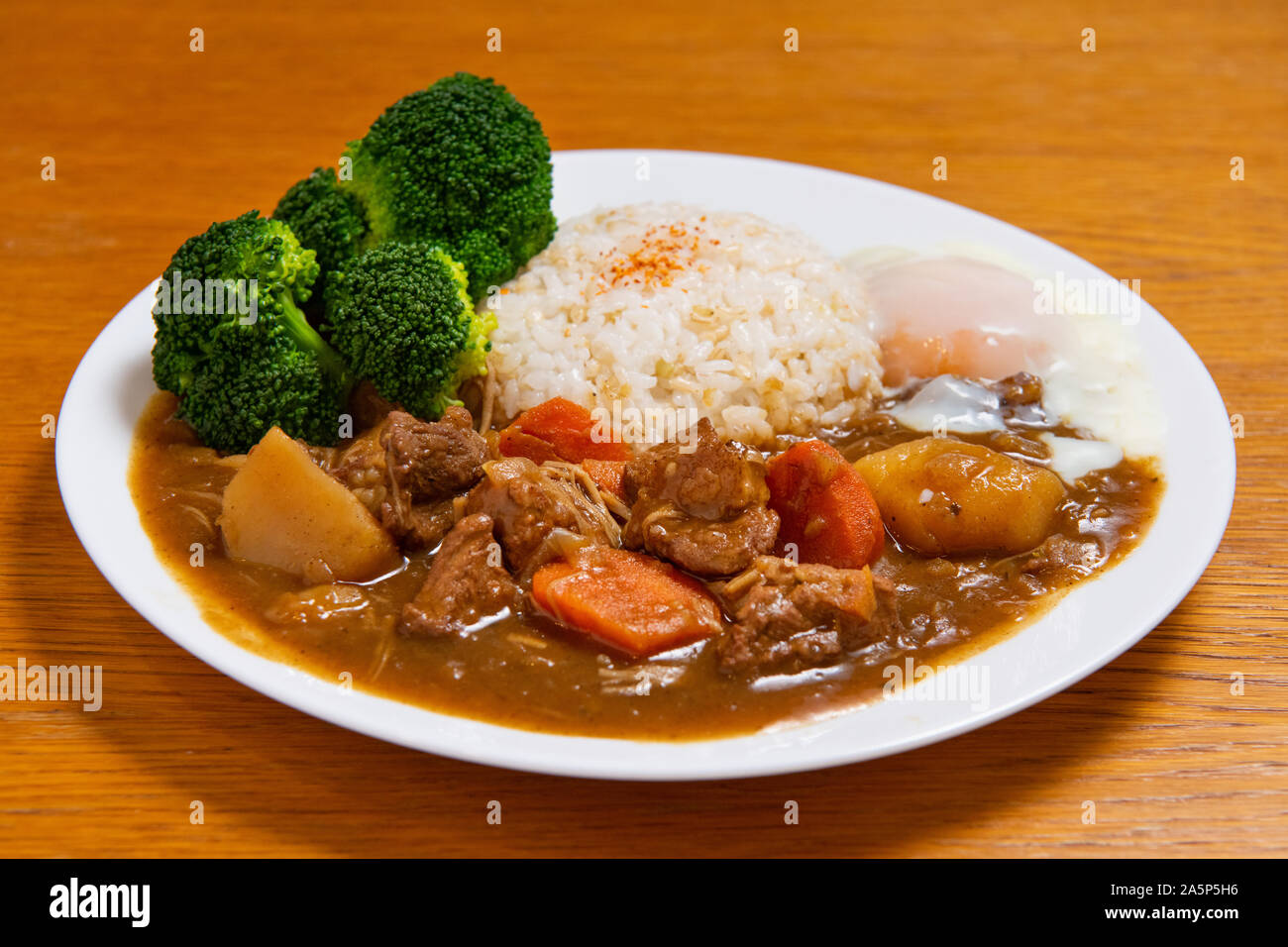 Pork Curry Rice on wooden background ( Onsen tamago, Potato, enoki ...