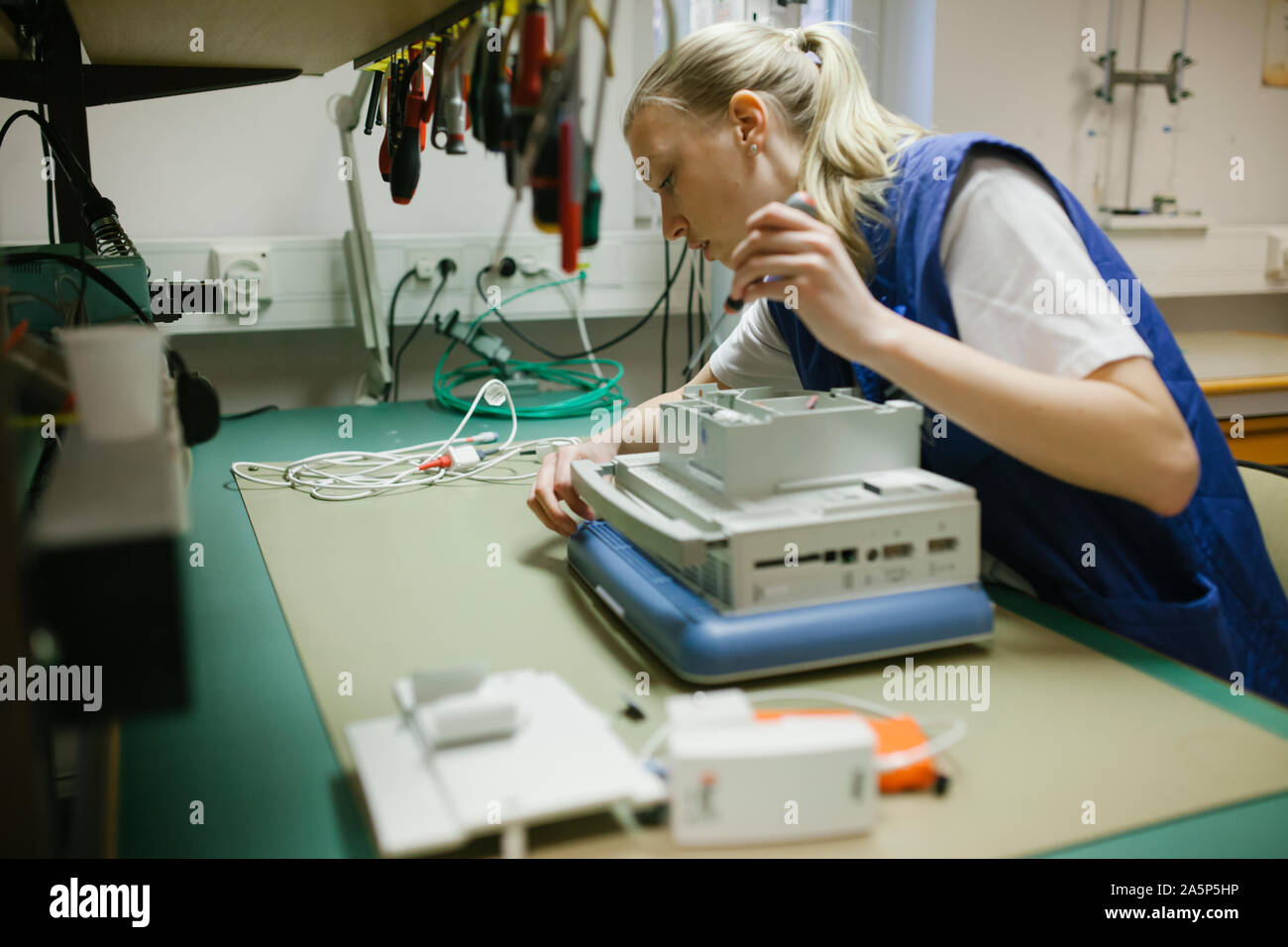 Female engineer repairing hospital equipment Stock Photo - Alamy
