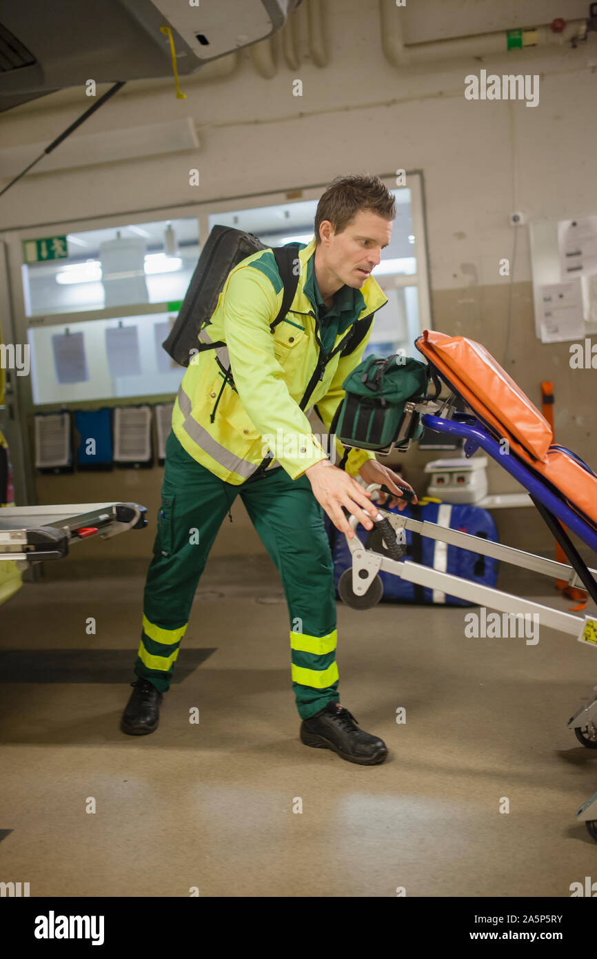 Paramedic putting stretcher Stock Photo - Alamy
