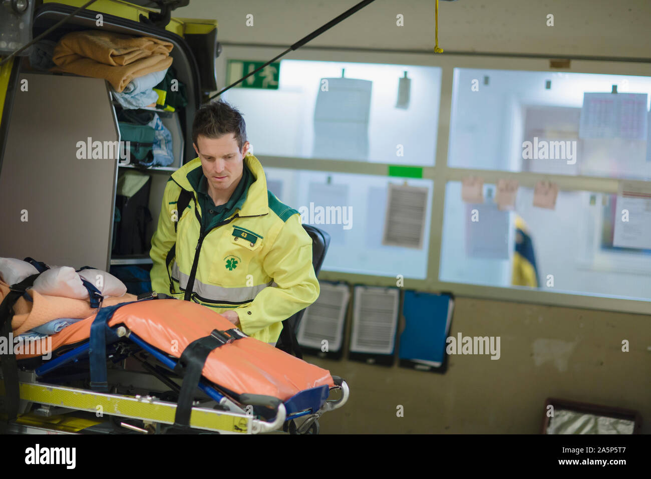 Paramedic putting stretcher in ambulance Stock Photo - Alamy