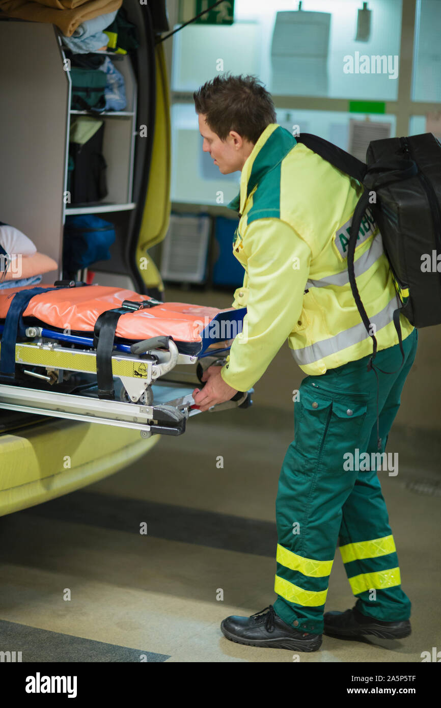 Paramedic putting stretcher in ambulance Stock Photo - Alamy