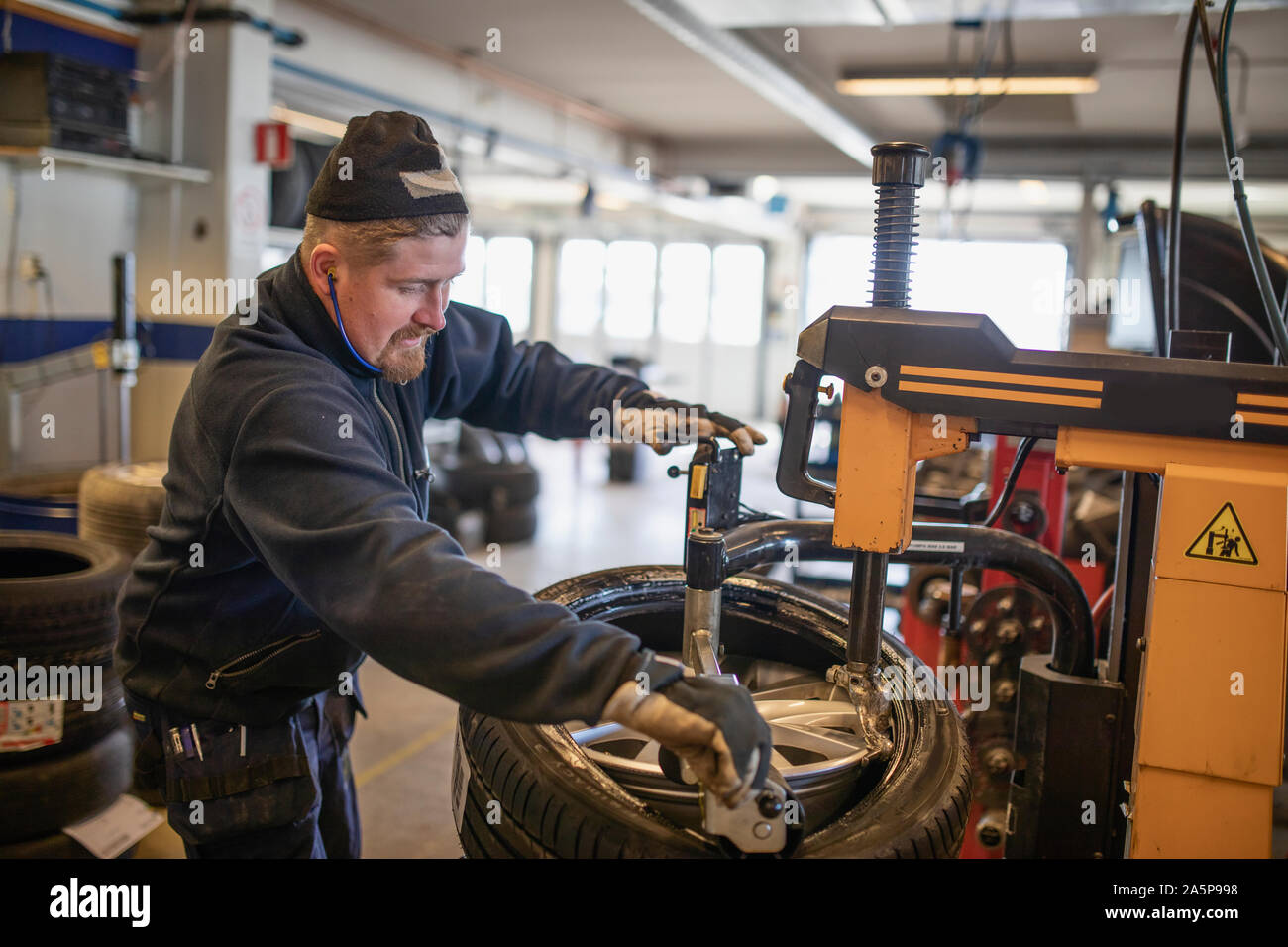 Man balancing the wheel in garage Stock Photo - Alamy