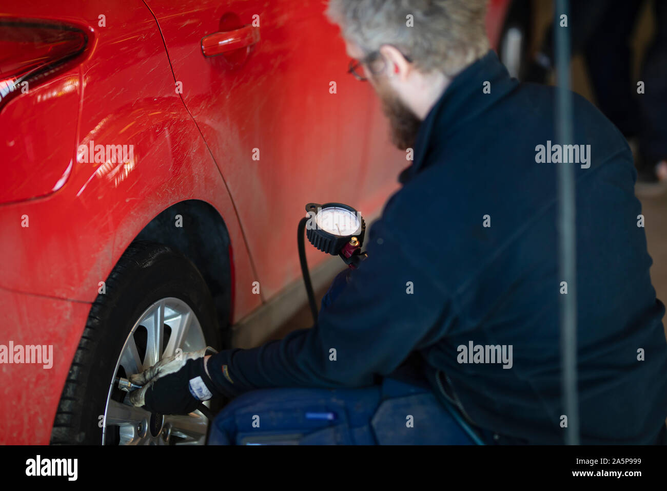 Man checking air tire pressure Stock Photo - Alamy