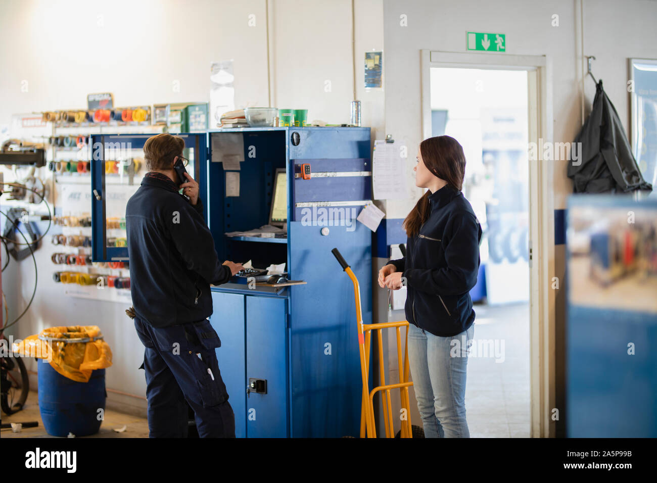 Mechanic and client in garage Stock Photo - Alamy