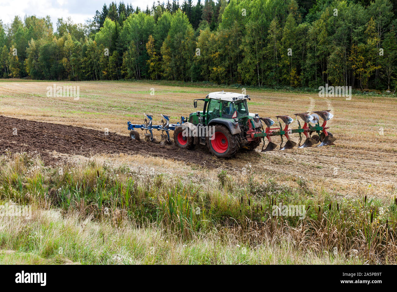 Tractor plowing field Stock Photo - Alamy