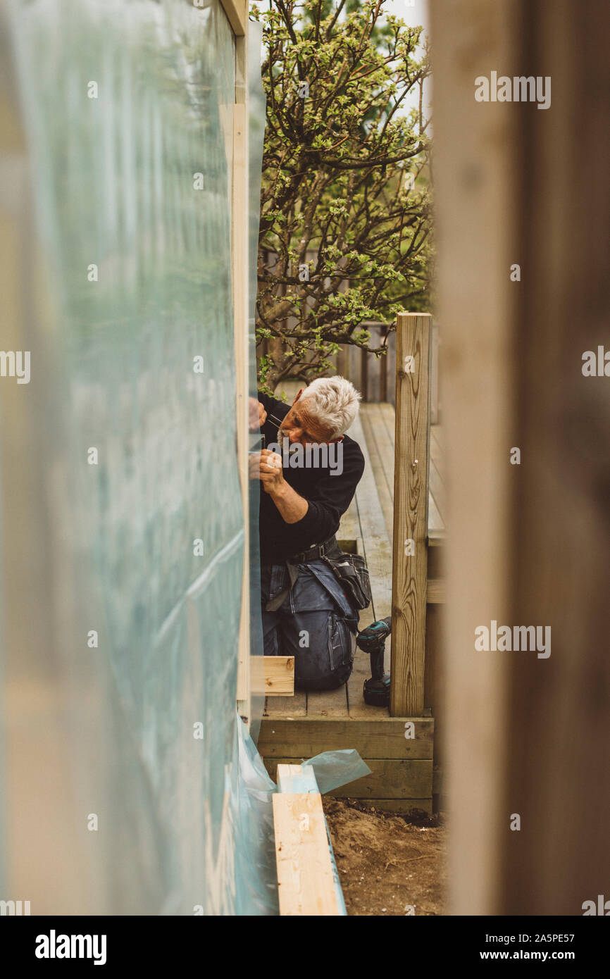 Senior man repairing fence Stock Photo - Alamy