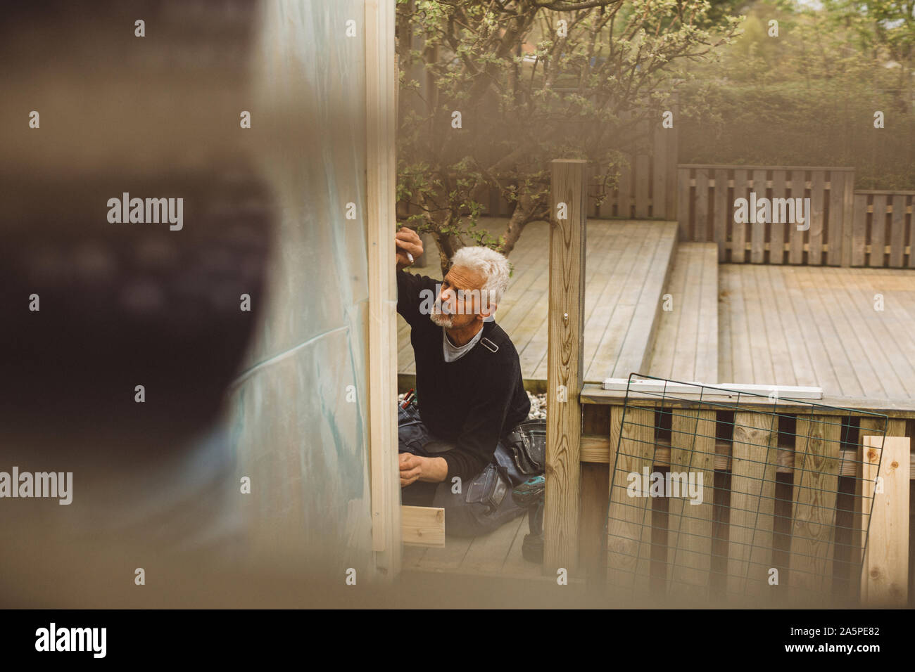 Senior man repairing fence Stock Photo - Alamy