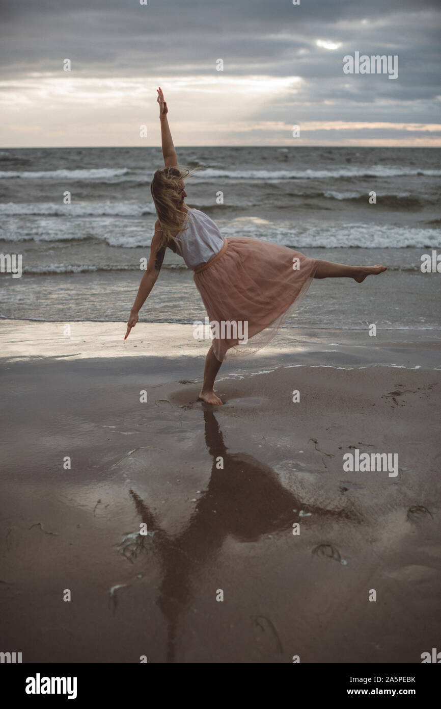 Young woman dancing on beach Stock Photo - Alamy