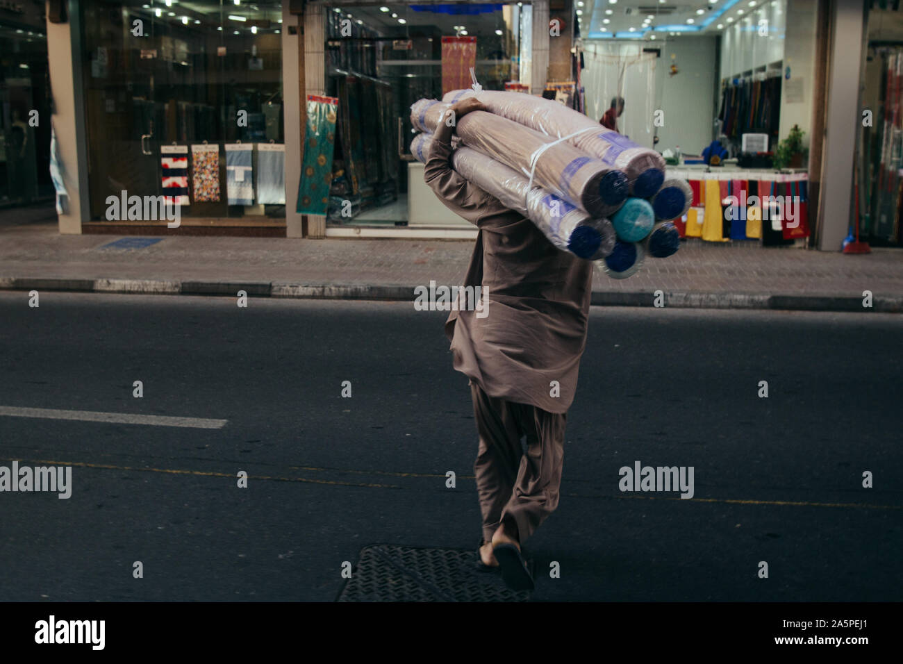 Man carrying carpet in Old Dubai Stock Photo - Alamy