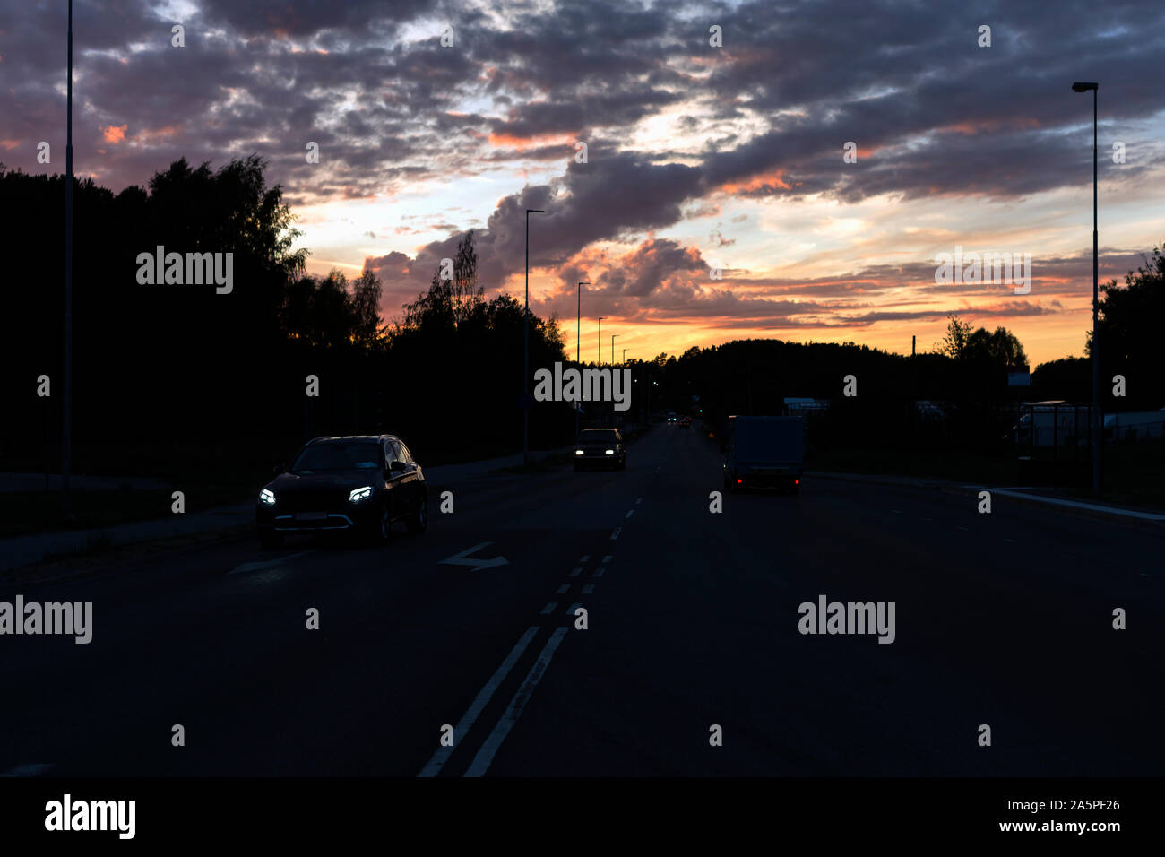 Cars on road at sunset Stock Photo - Alamy
