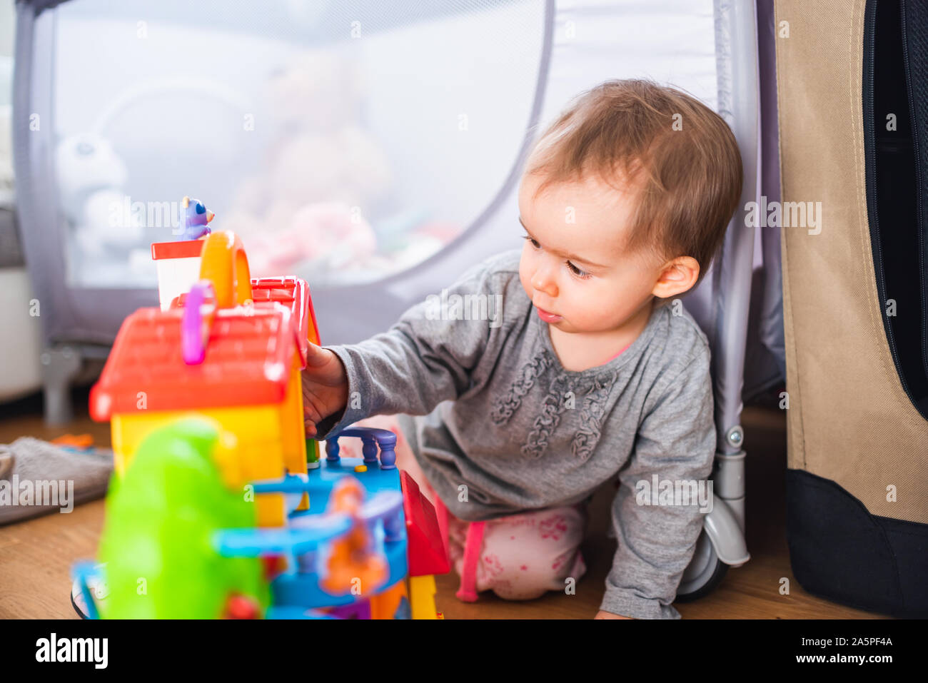 Cute little baby playing with toys in living room on a carpet floor ...