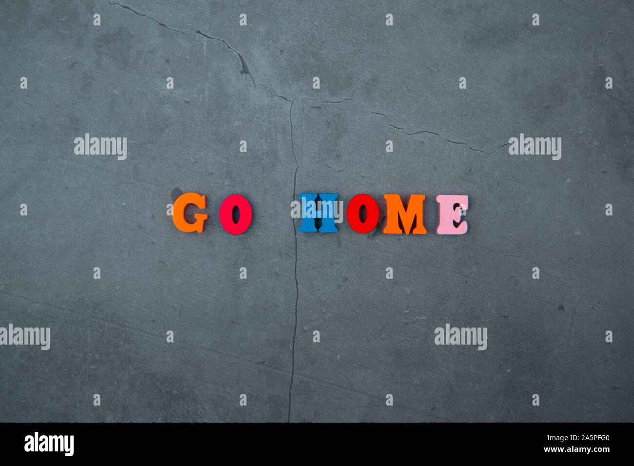 The multicolored go home word is made of wooden letters on a grey ...