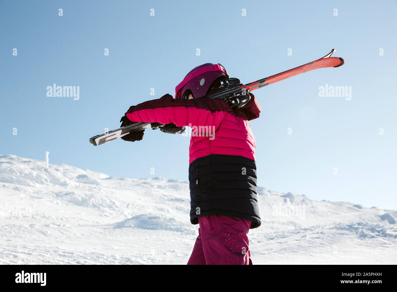 Girl carrying skis in mountains Stock Photo - Alamy