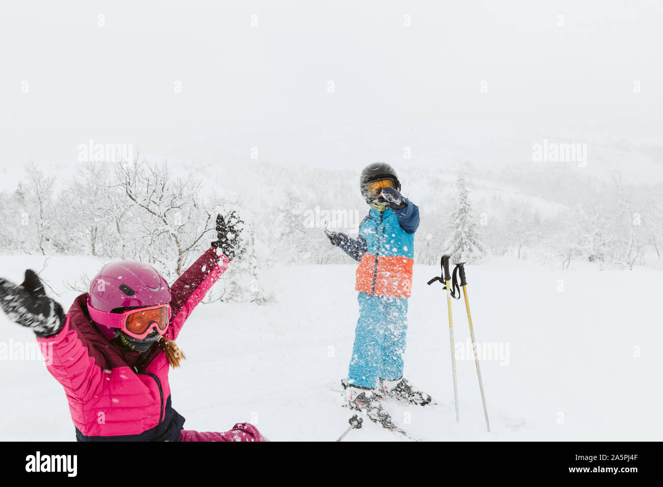 Boy and girl on ski slope Stock Photo - Alamy